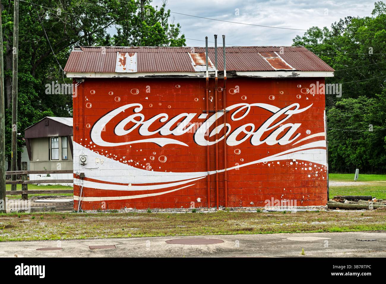 Coca Cola trademark logo sign advertising painted on the side of a small out building in ...
