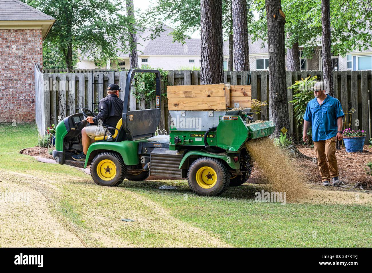 John Deere 4x2 Gator being used to sand or top dress a residential yard ...