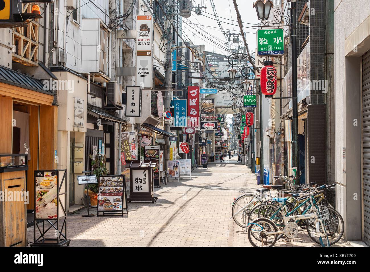 Narrow street in Osaka’s Namba district lined with restaurants ...