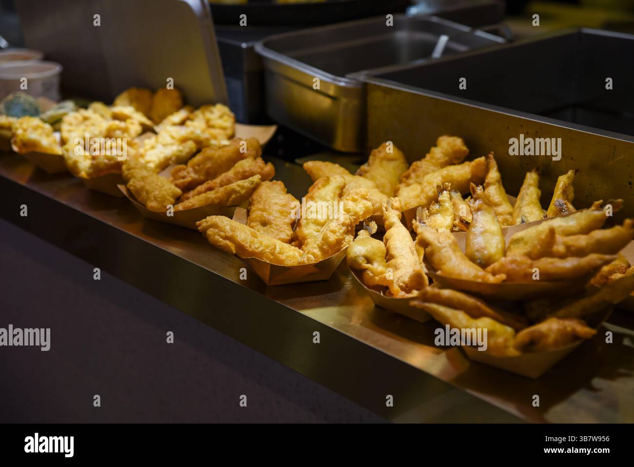 Golden battered fish fillets displayed in paper trays at a Chinese ...