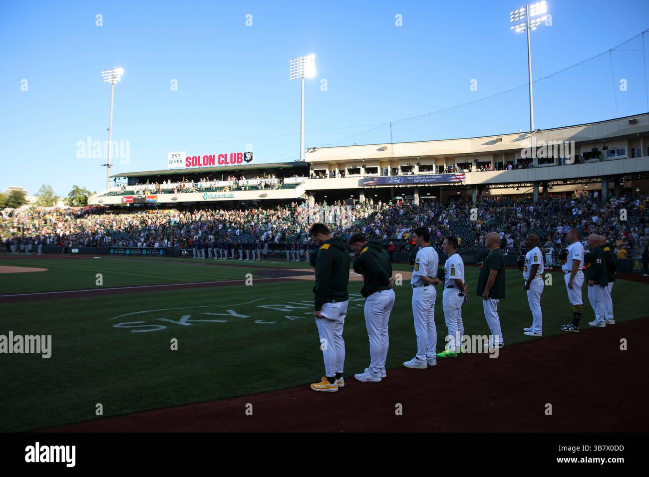 The Athletics and Seattle Mariners stand during the national anthem ...