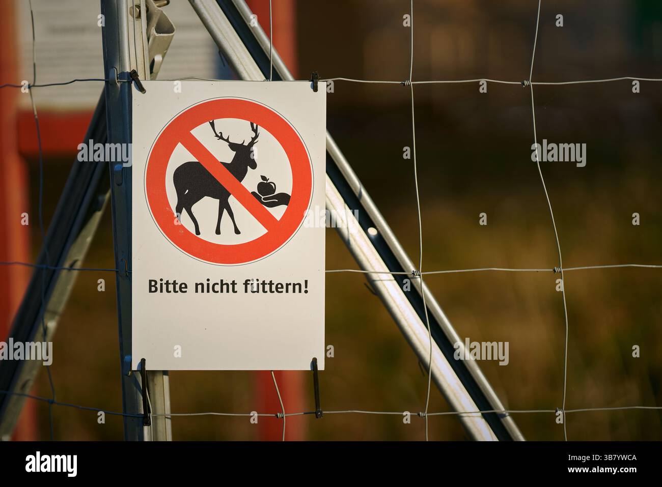 Sign on the fence of a game enclosure with the German inscription Bitte ...