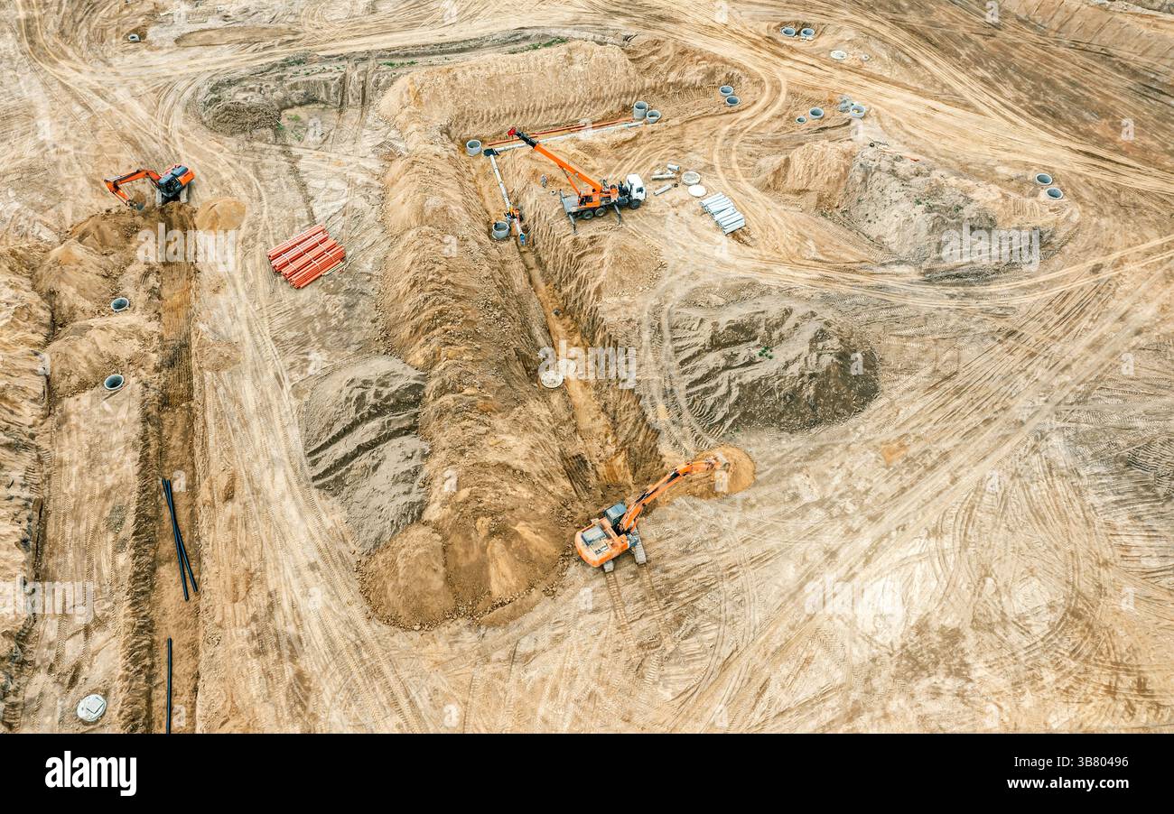 truck crane and the excavator install sewerage system on a construction ...