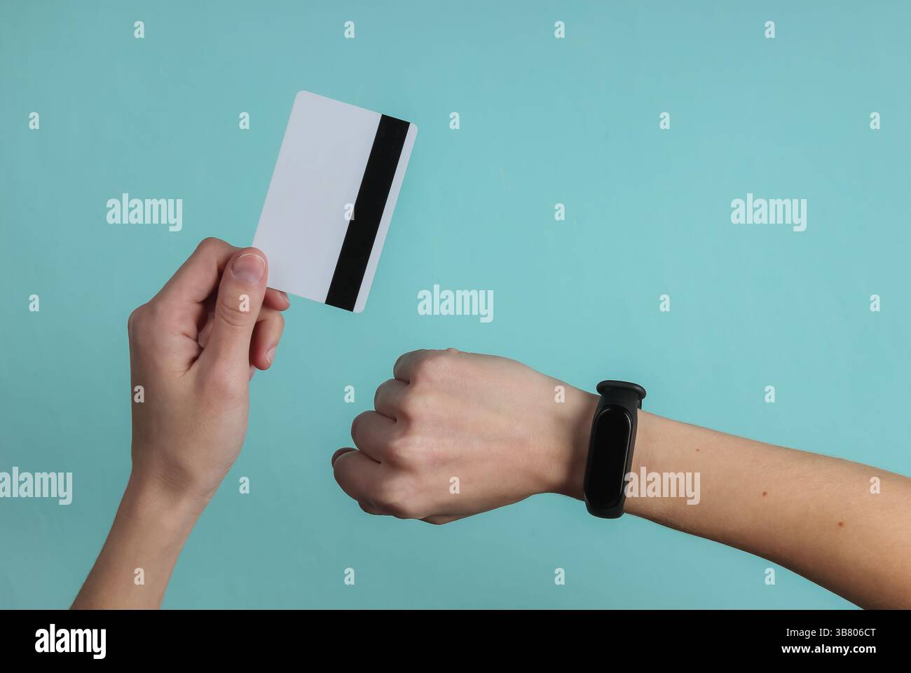 Hand with smart bracelet holding bank card on blue background. Cashless ...
