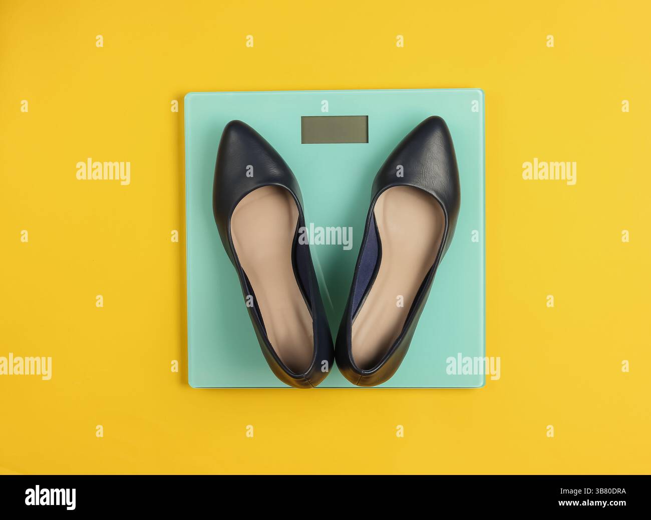 Women's classic high-heeled shoes on floor scales. Yellow studio ...