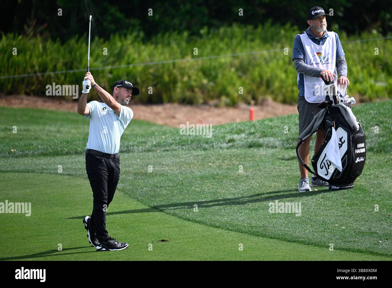 Brian Harman, left, looks on after hitting from the eighth fairway ...