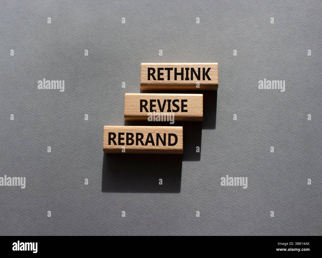 Rethink Revise Rebrand symbol. Wooden blocks with words Rethink Revise Rebrand. Beautiful grey ...