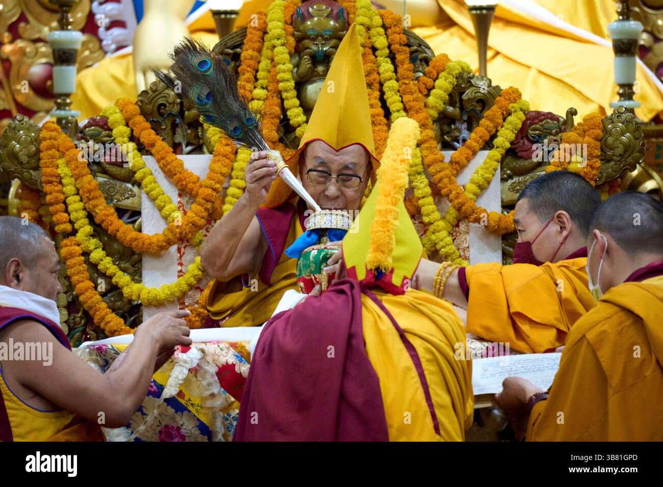 Tibetan spiritual leader the Dalai Lama wears a ceremonial hat as he ...