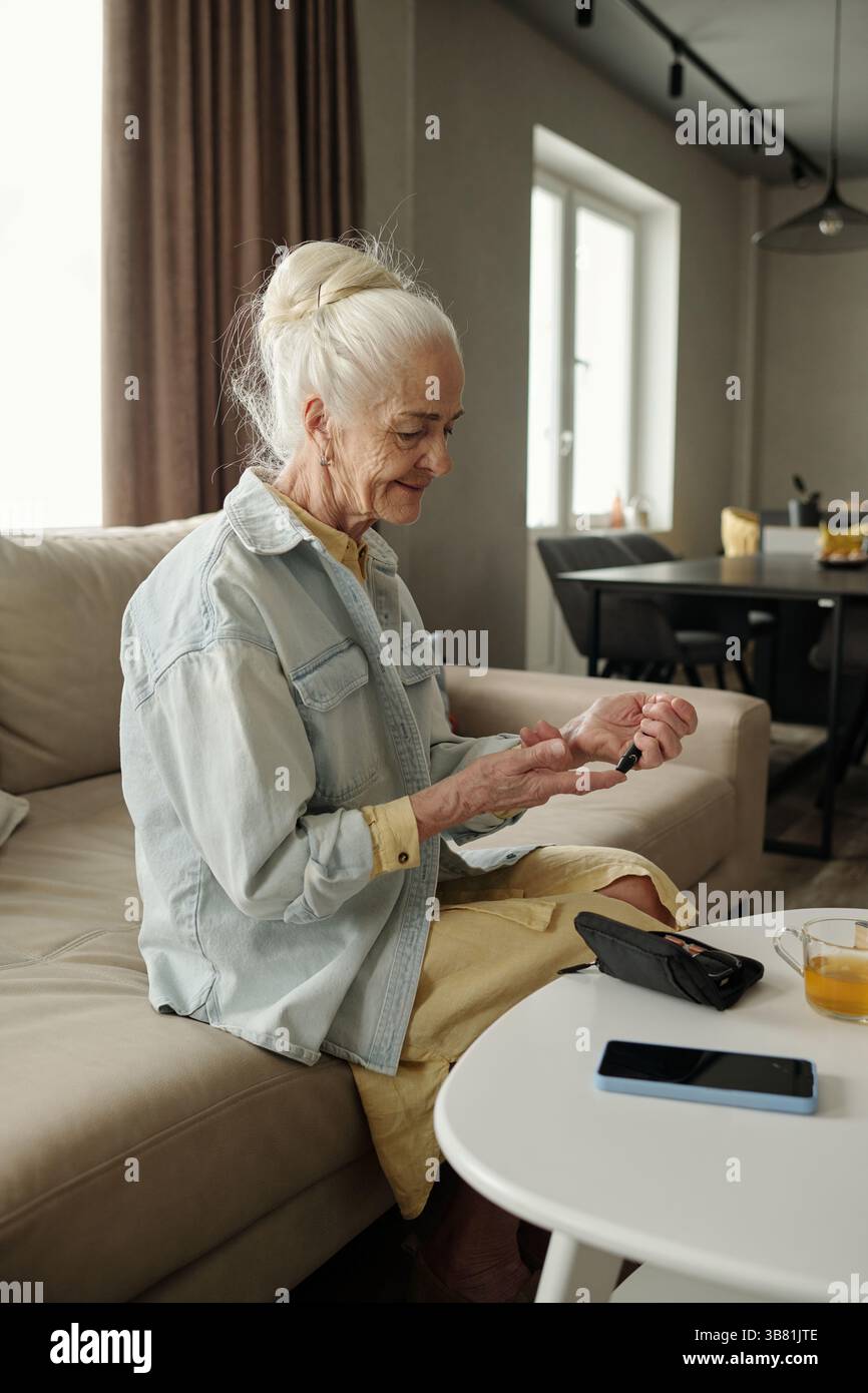 Elderly woman using glucometer hi-res stock photography and images - Alamy