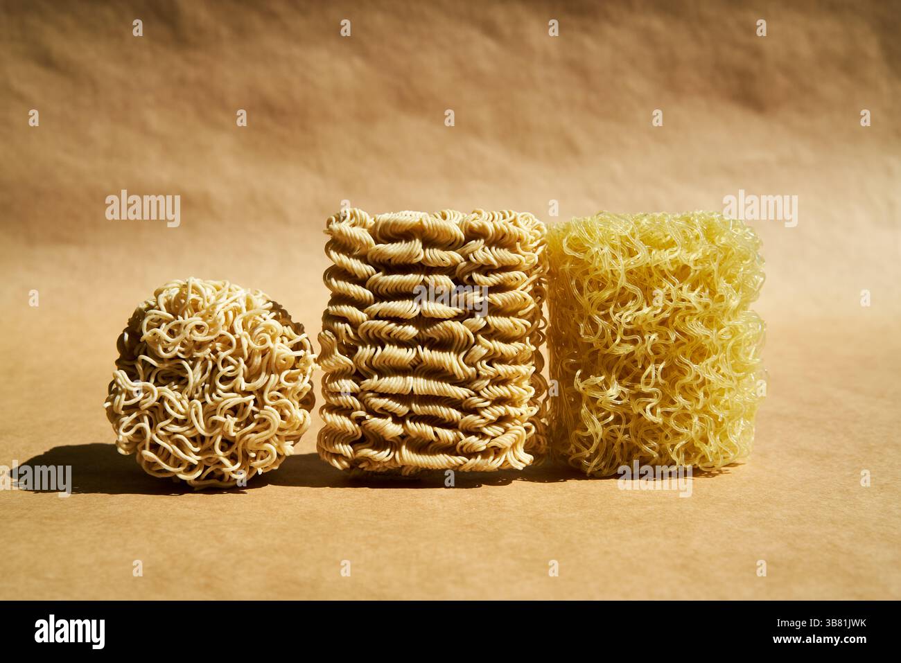 Various dry instant noodle blocks over brown background. Food concept ...
