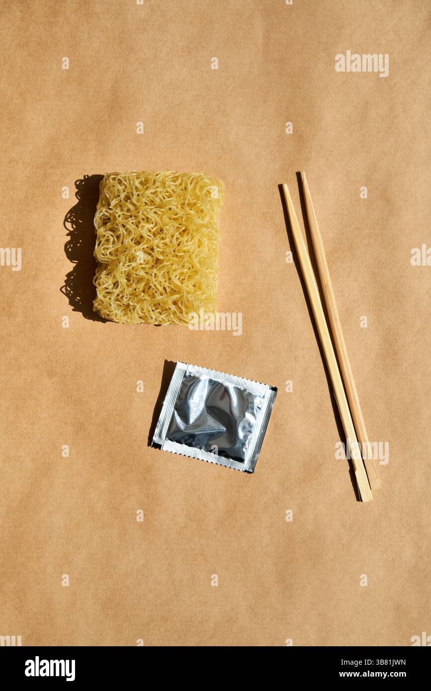 Dry instant noodles with wooden chopsticks and seasoning packet over ...