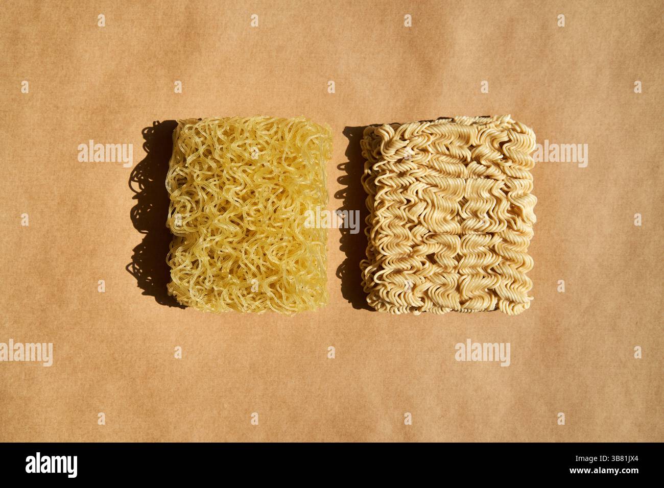 Two dry instant noodle blocks on brown paper background. Food concept ...