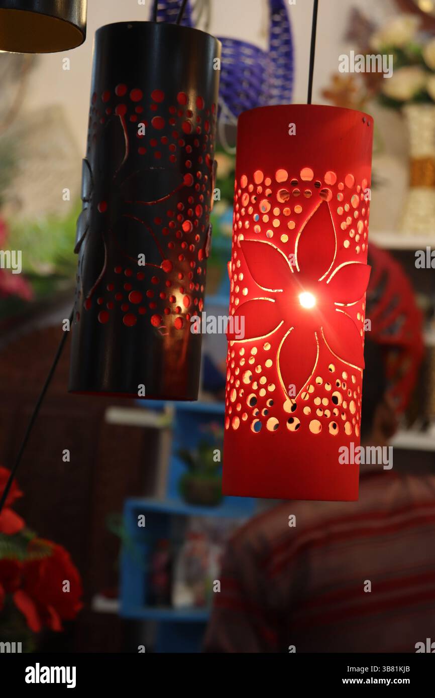 Cylindrical lamps, one red and one black, illuminate a room, casting ...