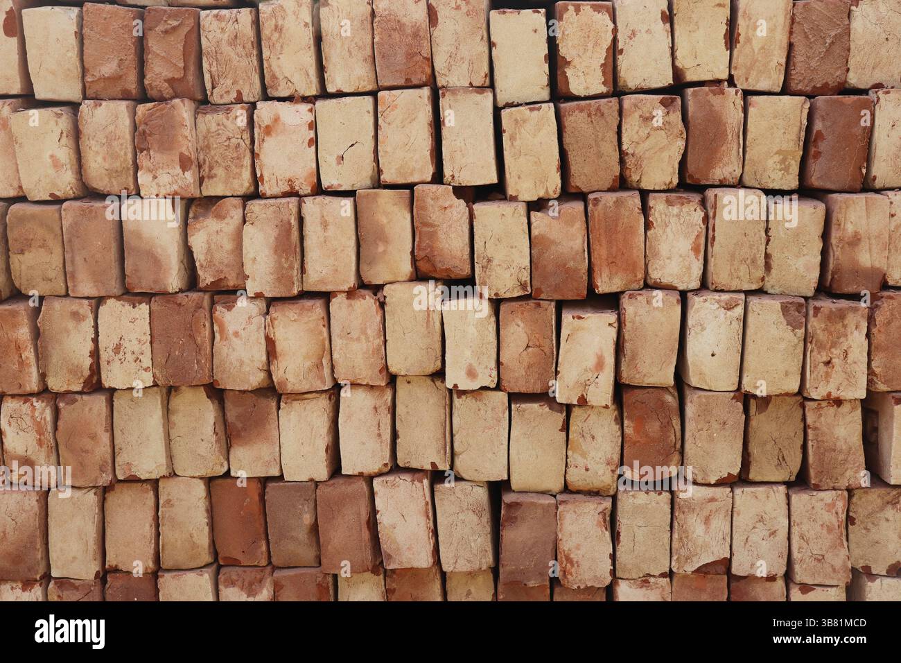 Close up shows stacked bricks with variations of beige and earthy red ...
