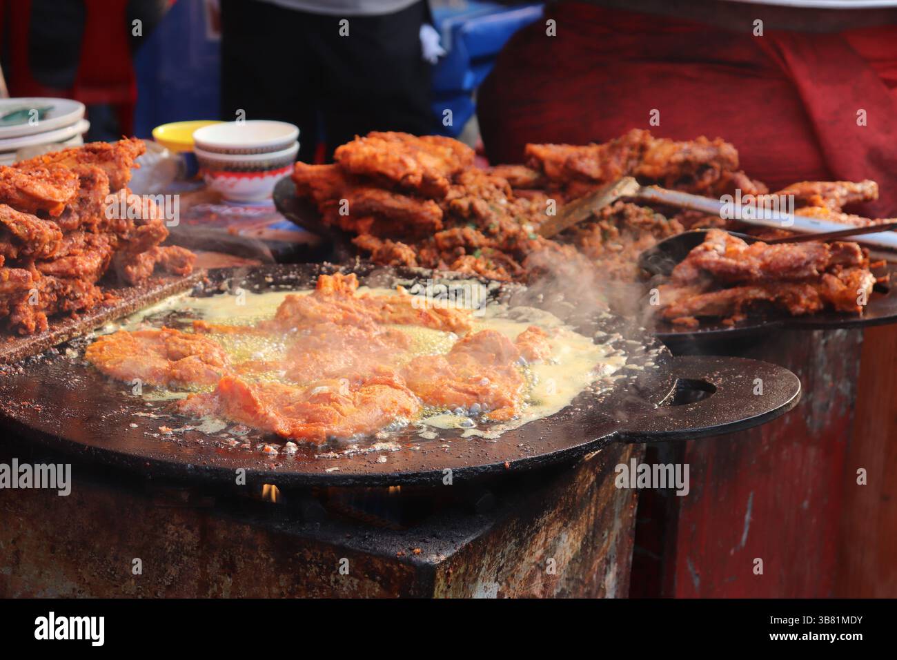 Eye-level, extreme close-up displays hot sizzling chicken being deep ...