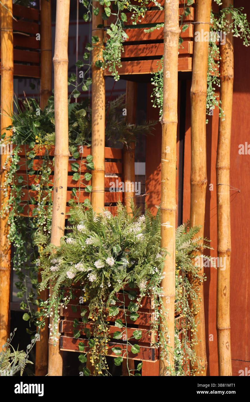 Wooden planters overflowing with greenery and hanging vines are ...