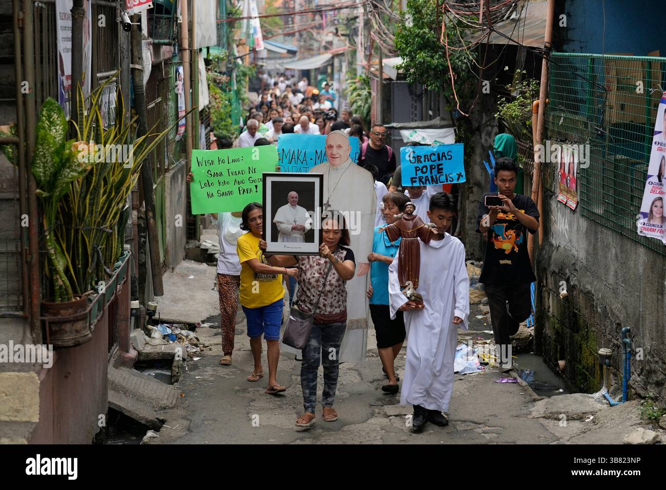 A cardboard cutout and picture of the late Pope Francis is carried by ...