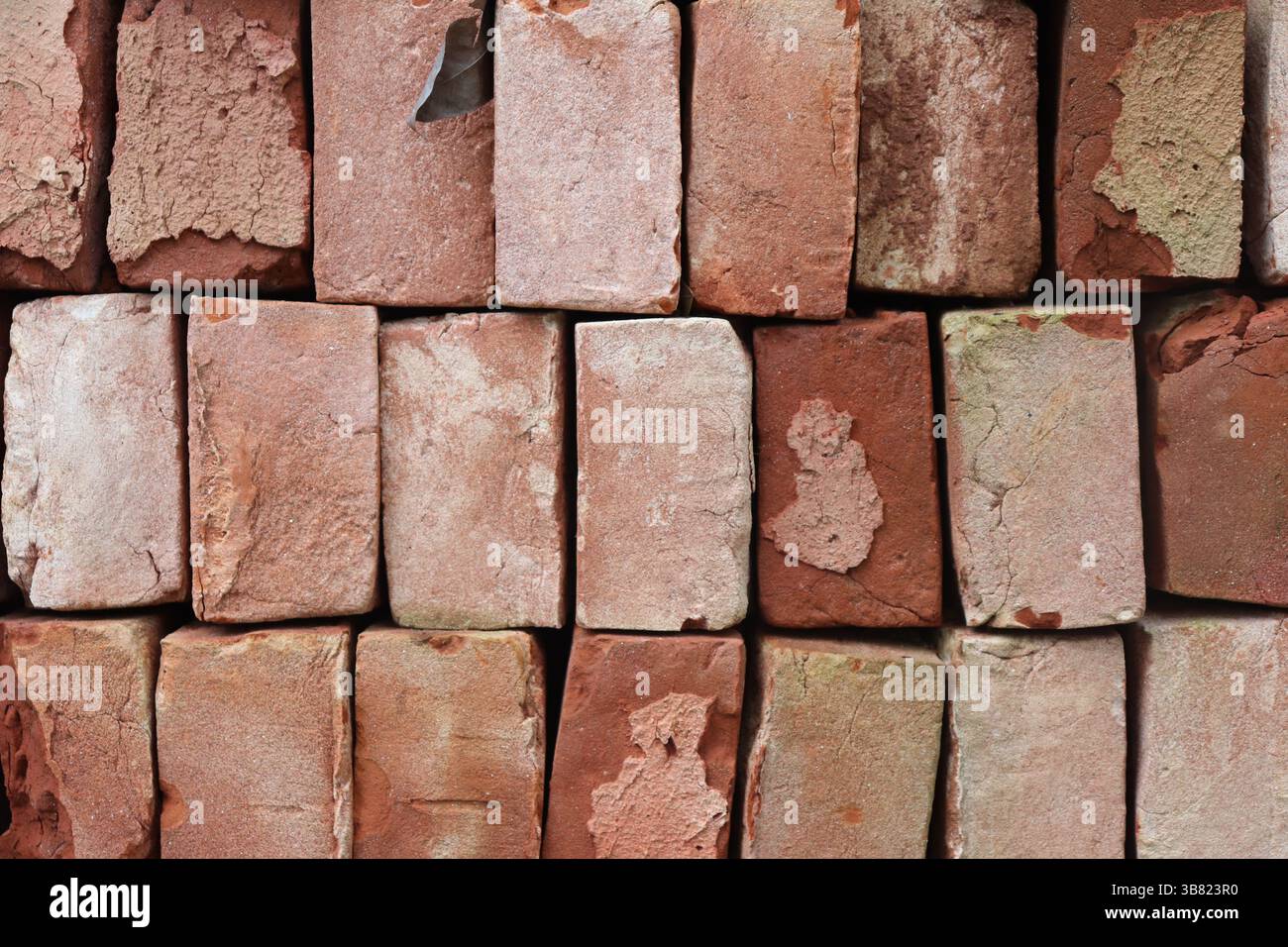 Close up shows worn and aged red bricks stacked neatly. Texture detail ...