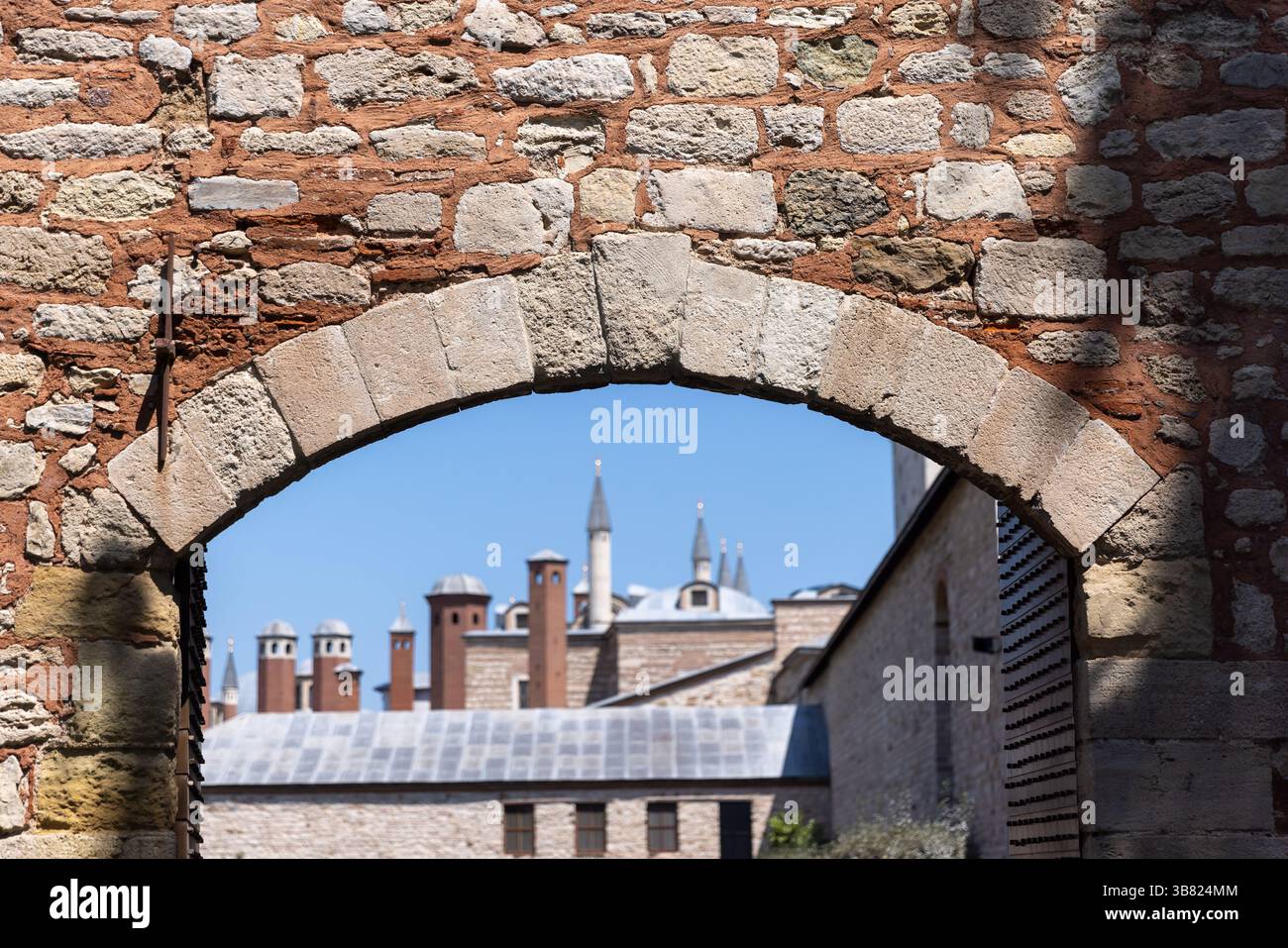 A historic stone archway frames a view of traditional architectural ...