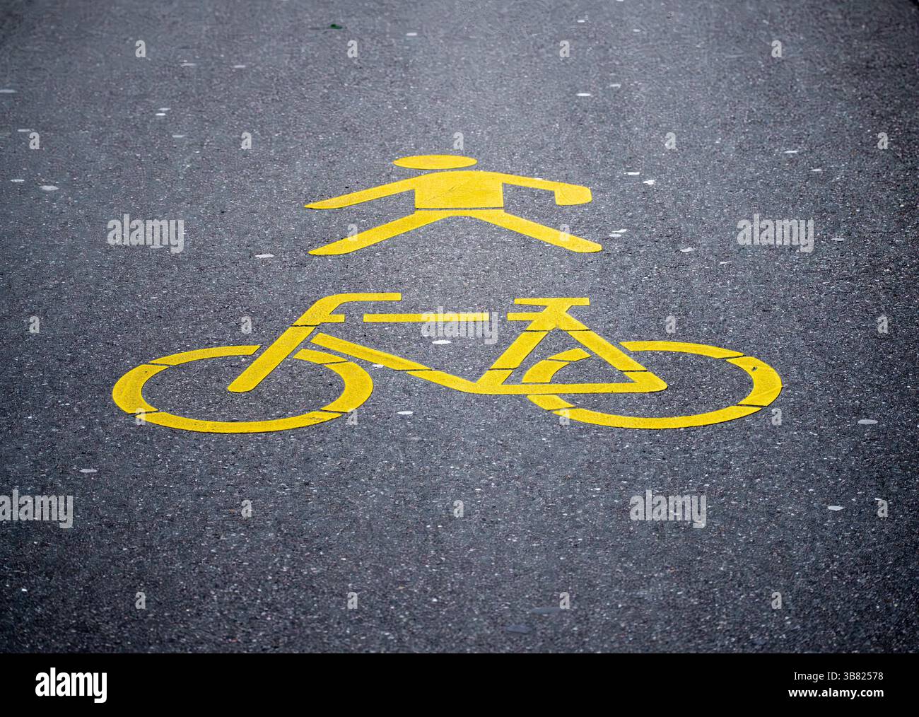 A close-up view of a road surface featuring yellow pedestrian and ...
