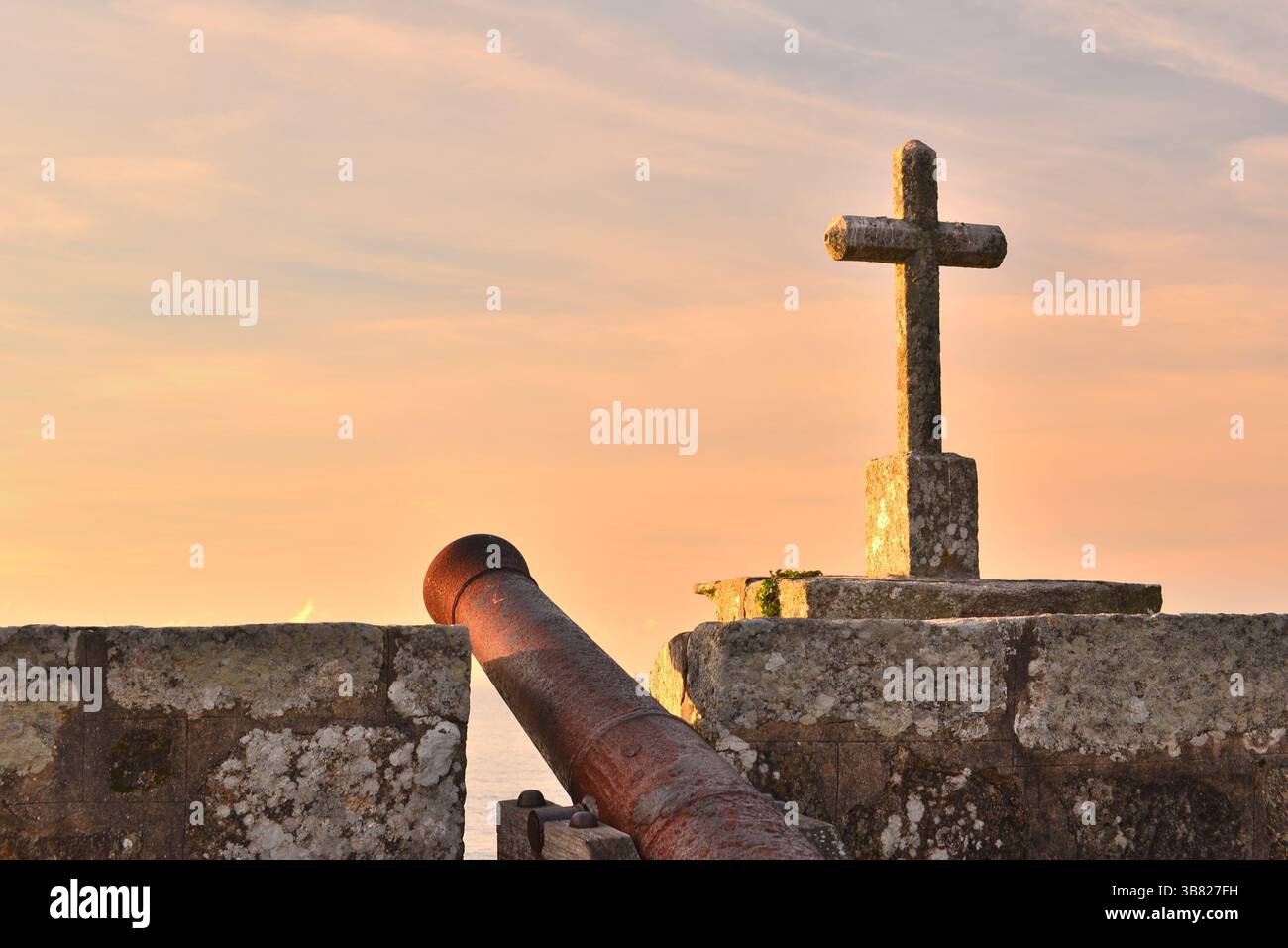 Controversial image with a cross and a cannon Stock Photo - Alamy