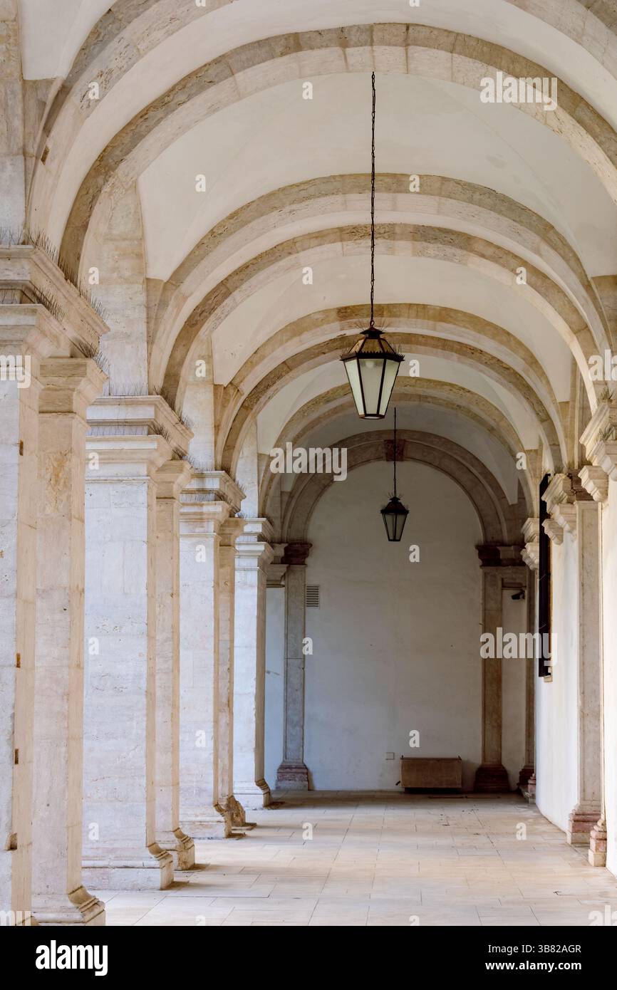 A hallway with arches and a light hanging from the ceiling. Graça ...