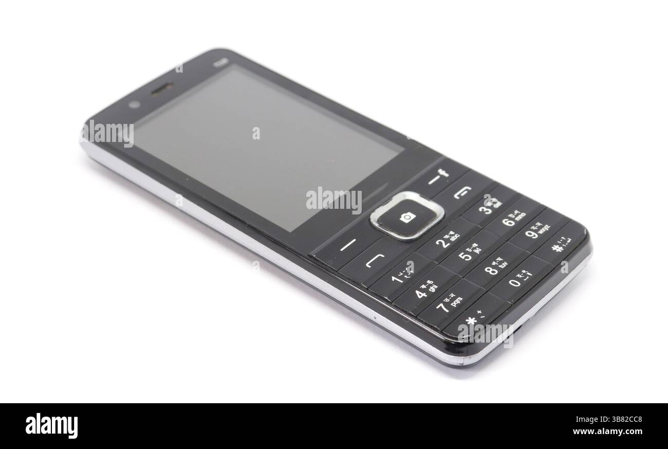 Captured against a white backdrop, an outdated black mobile phone ...