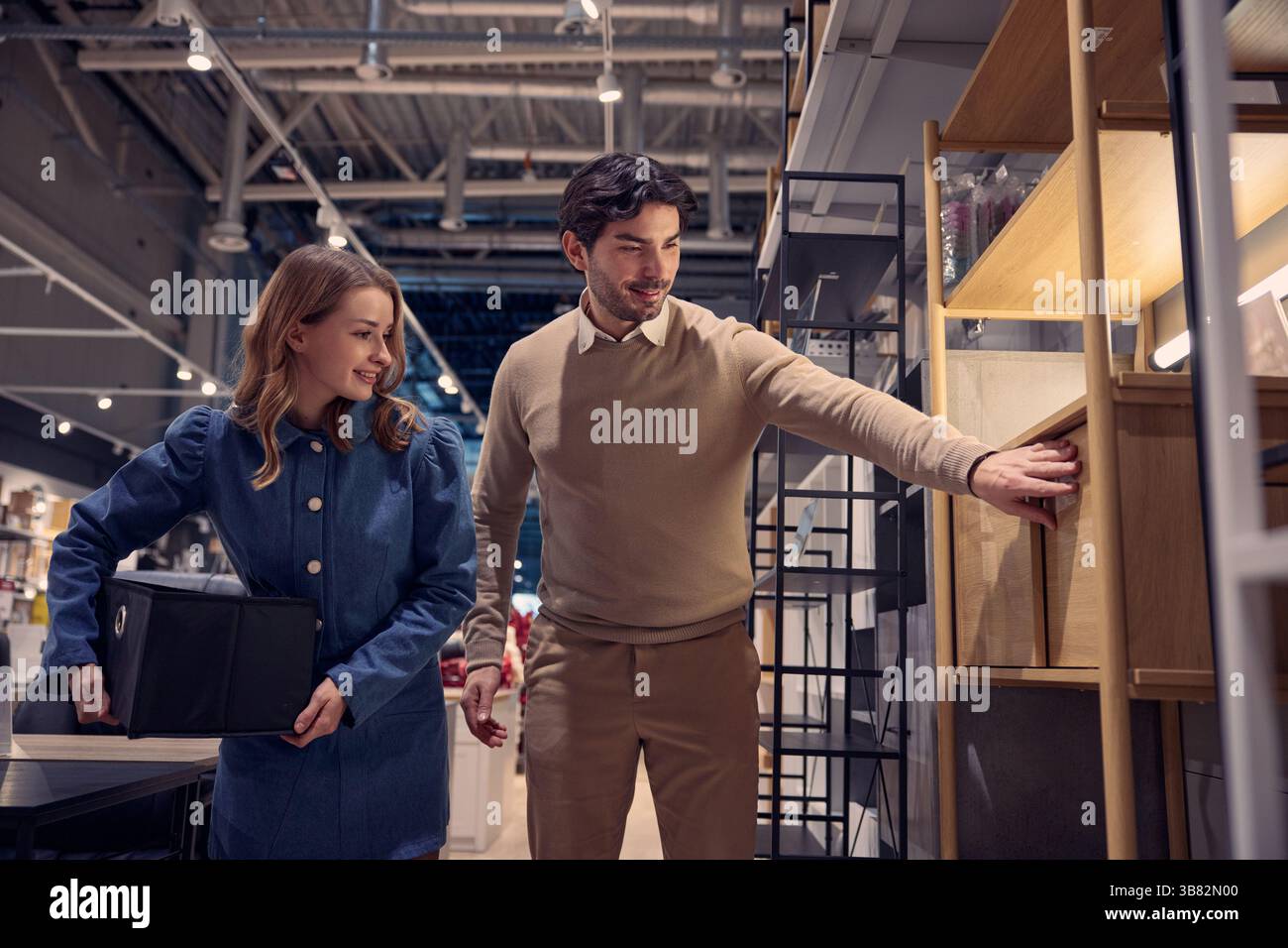 A couple is happily exploring a furniture store together, enjoying the ...