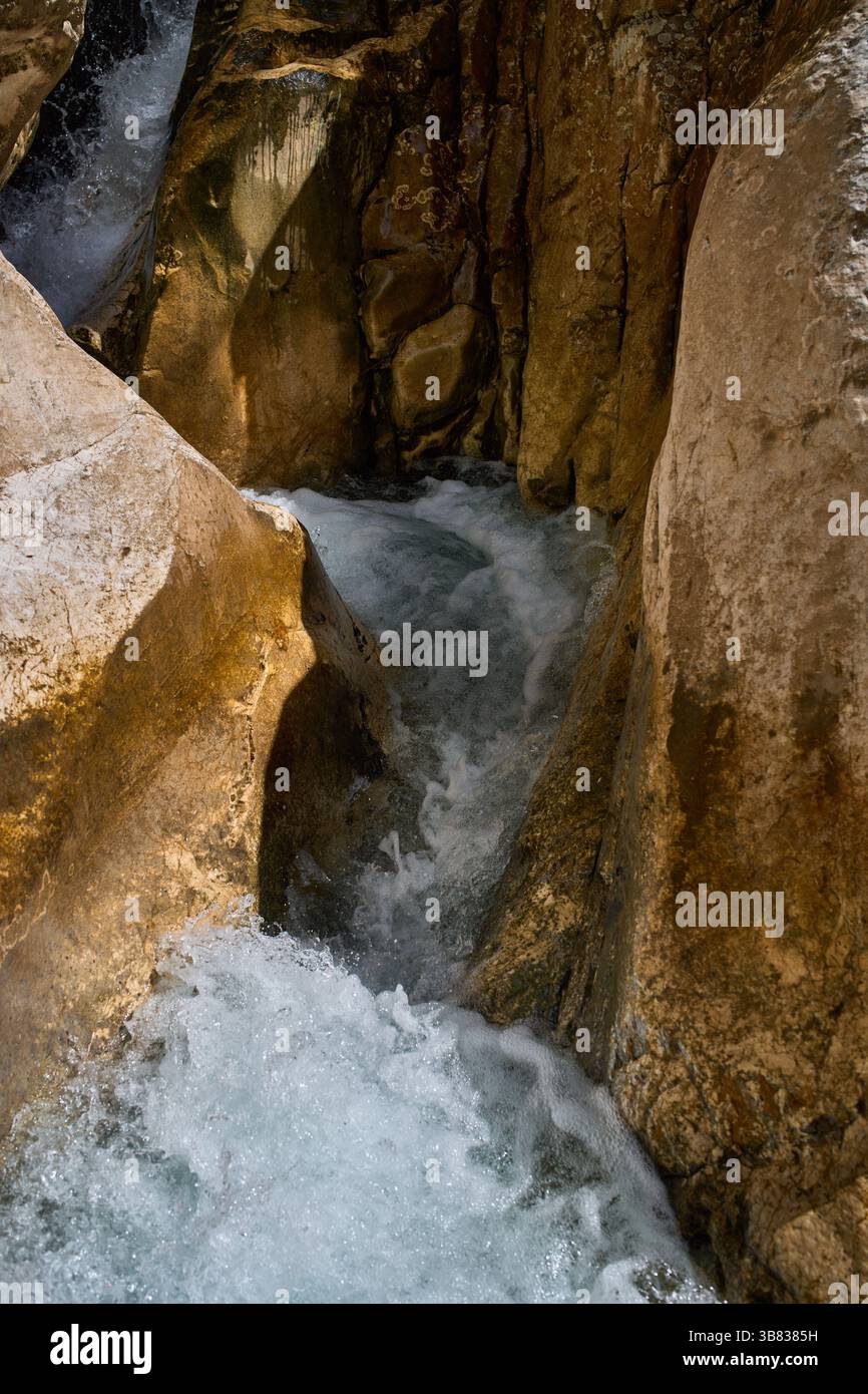 Powerful mountain stream cascading through narrow rocky limestone gorge ...