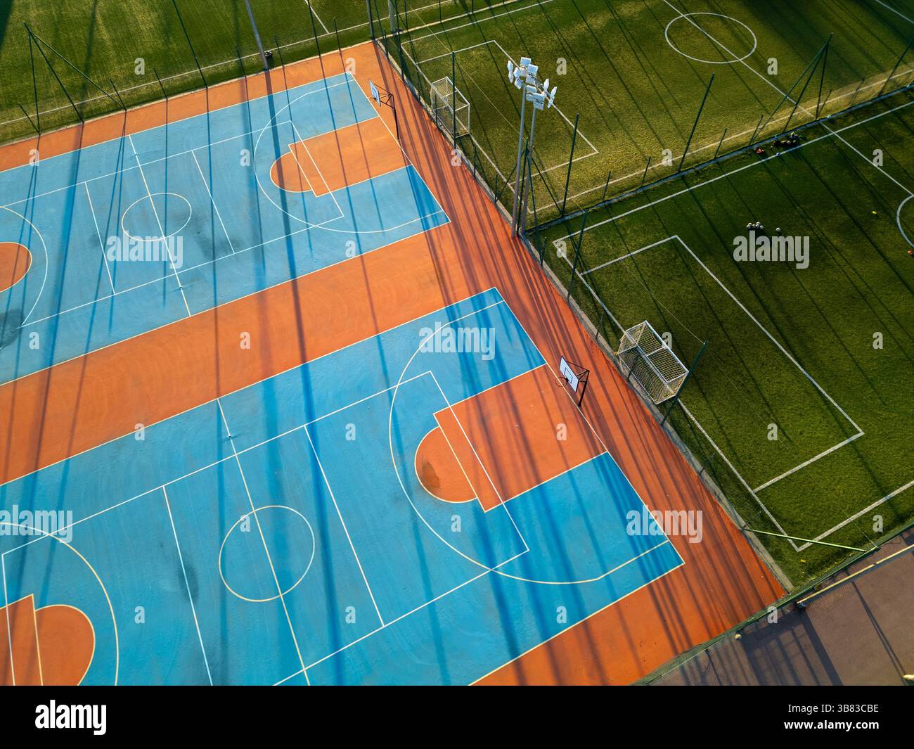 Outdoor basketball and soccer court at sunset with colorful surface ...