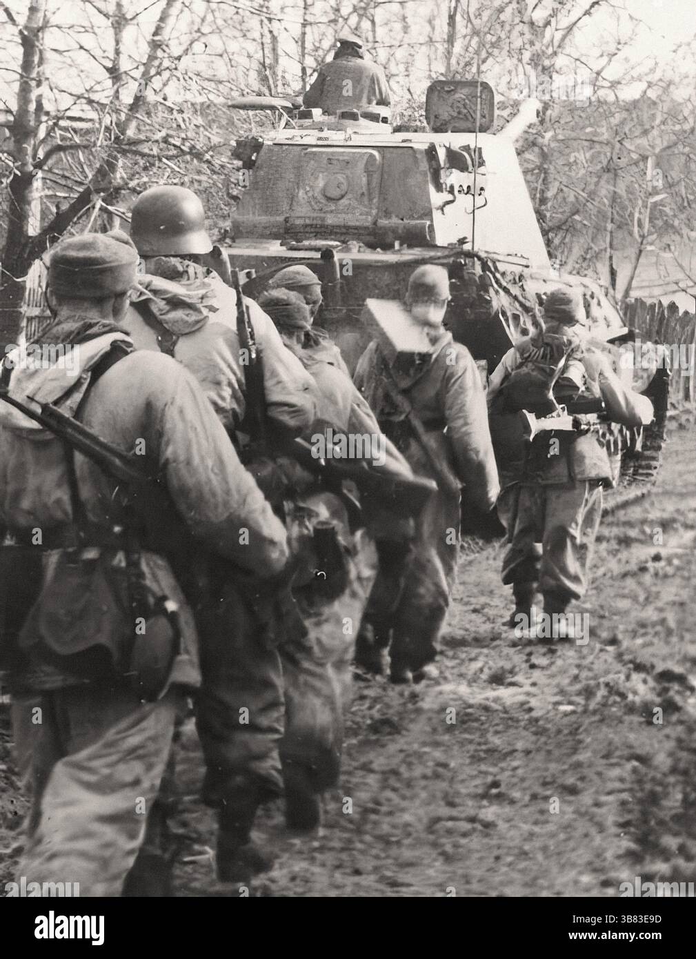 German troops follow a PzKpfw VI Tiger Ausf B during the winter 1944 ...