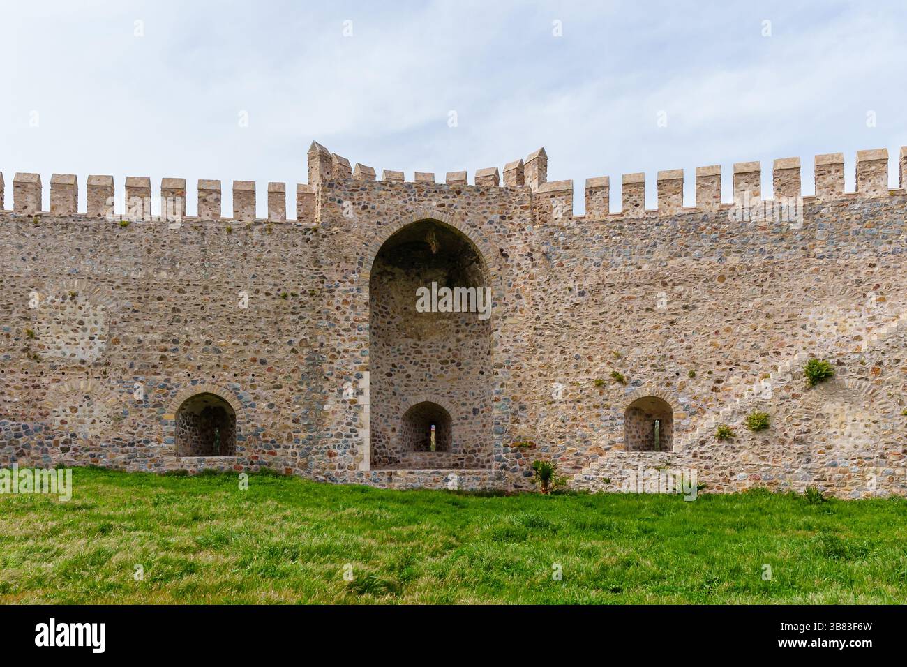 Beautiful arched stone gate entrance in the wall of an ancient fortress ...