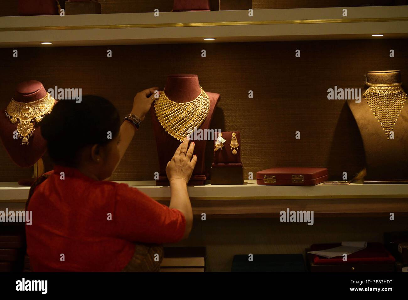 A salesman arranges gold jewellery ahead of 'Akshaya Tritiya,' an ...