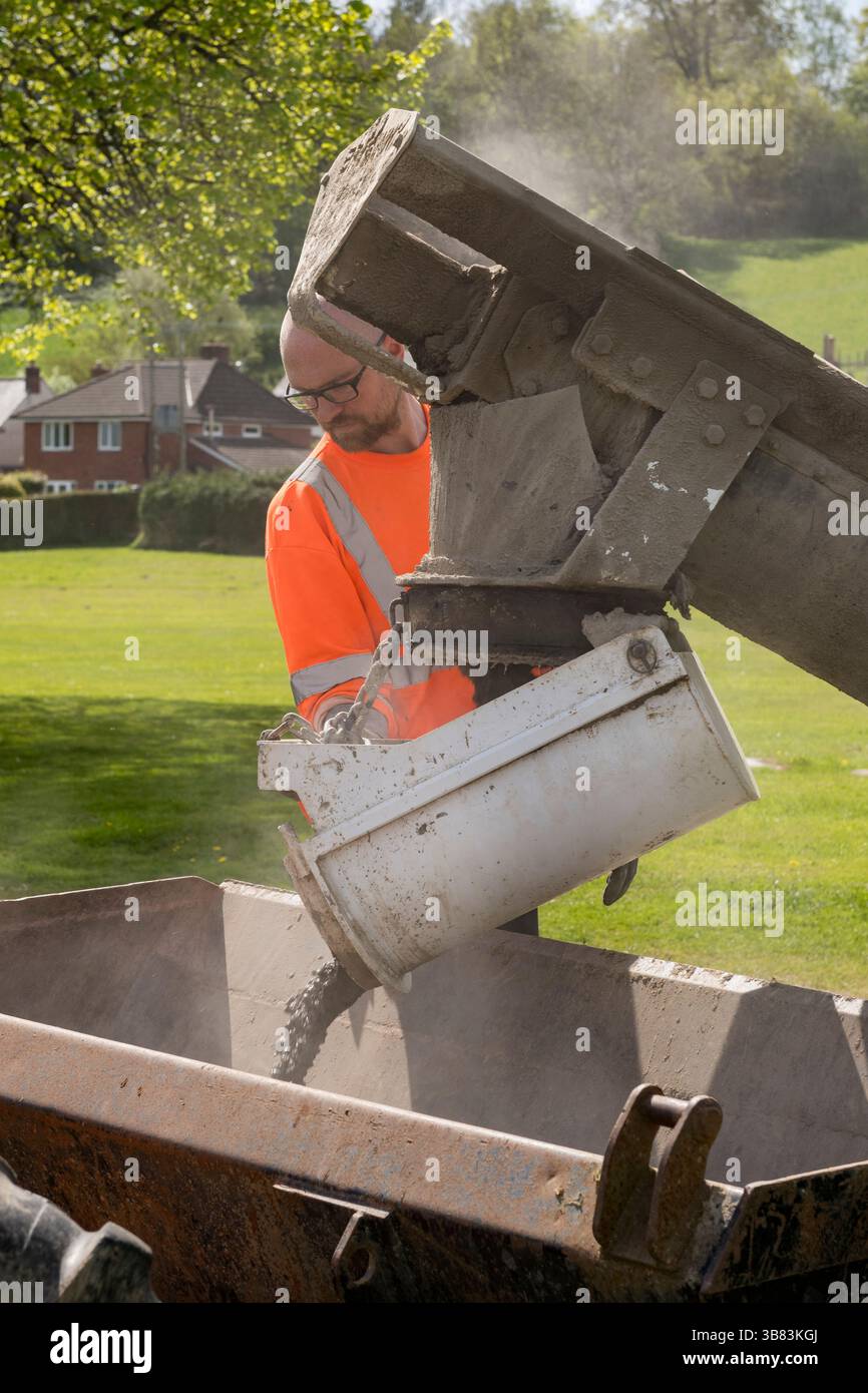 The driver of a concrete mixer lorry delivering ready mixed concrete to ...