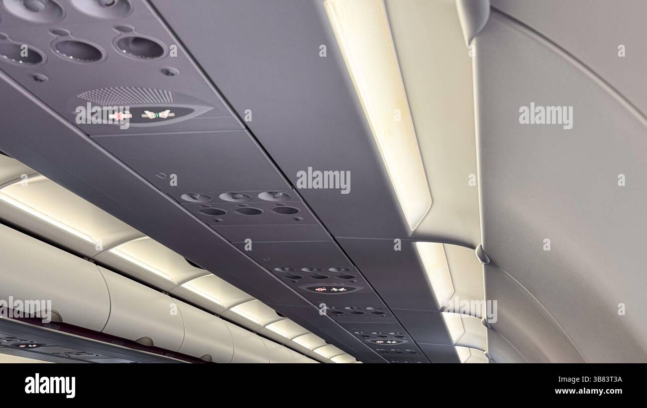 Interior view of airplane cabin ceiling with overhead aisle lights and ...
