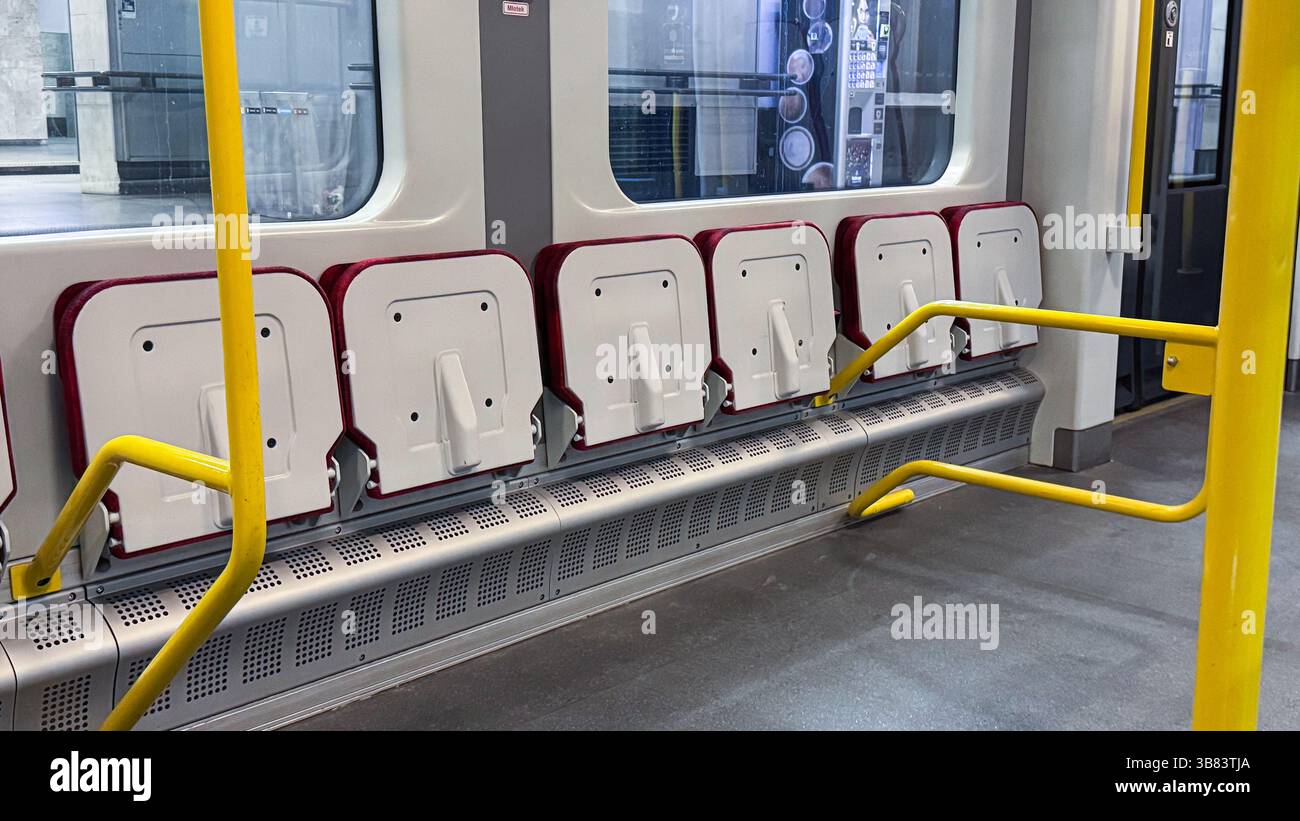 Modern urban subway interior featuring foldable red and white seats ...
