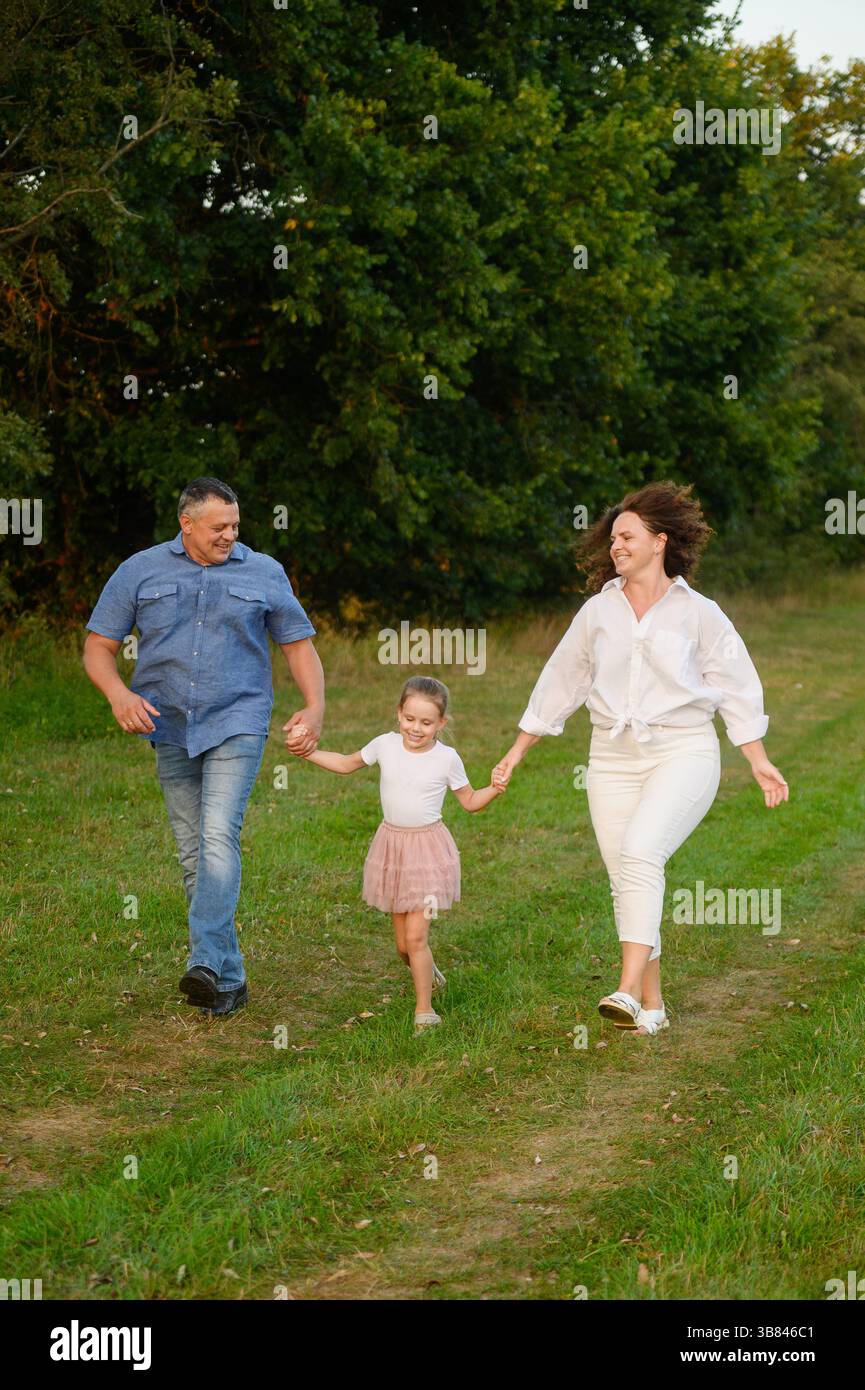 Family enjoying leisure in park, having fun, running together, jumping ...