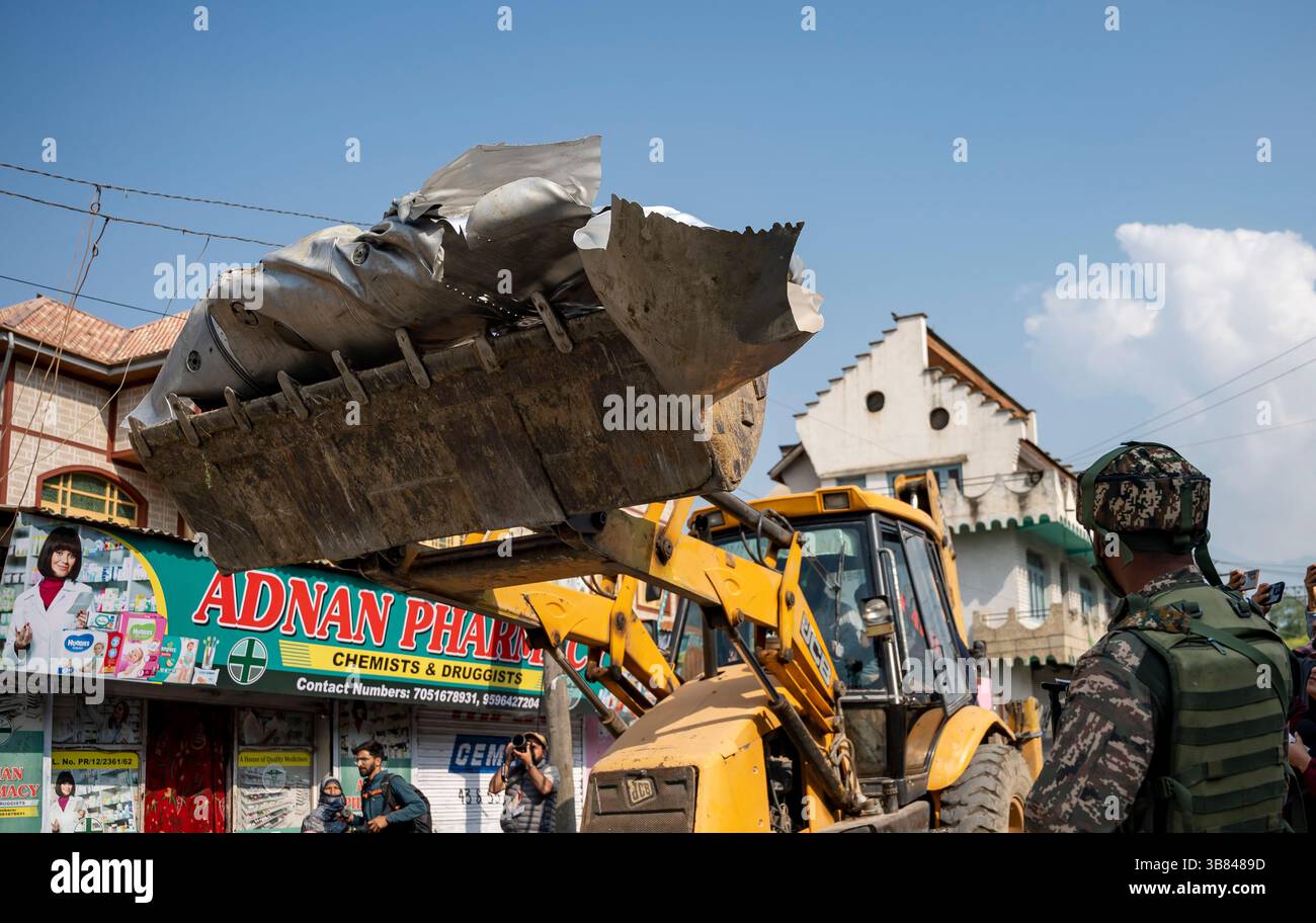 Wreckage is being carried by a bulldozer near the site where unknown ...