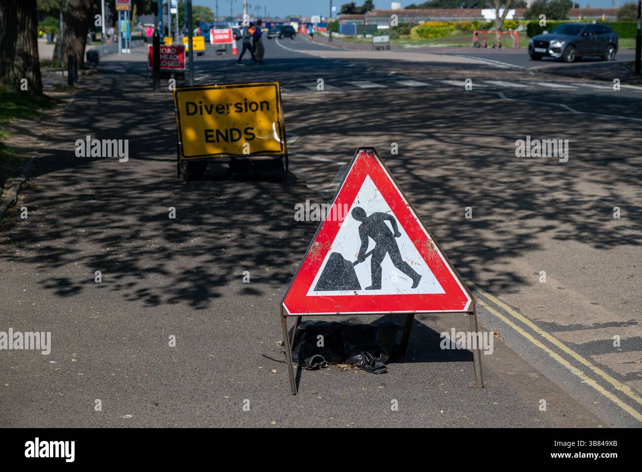 Red triangle sign for road works with diversion sign behind on an ...