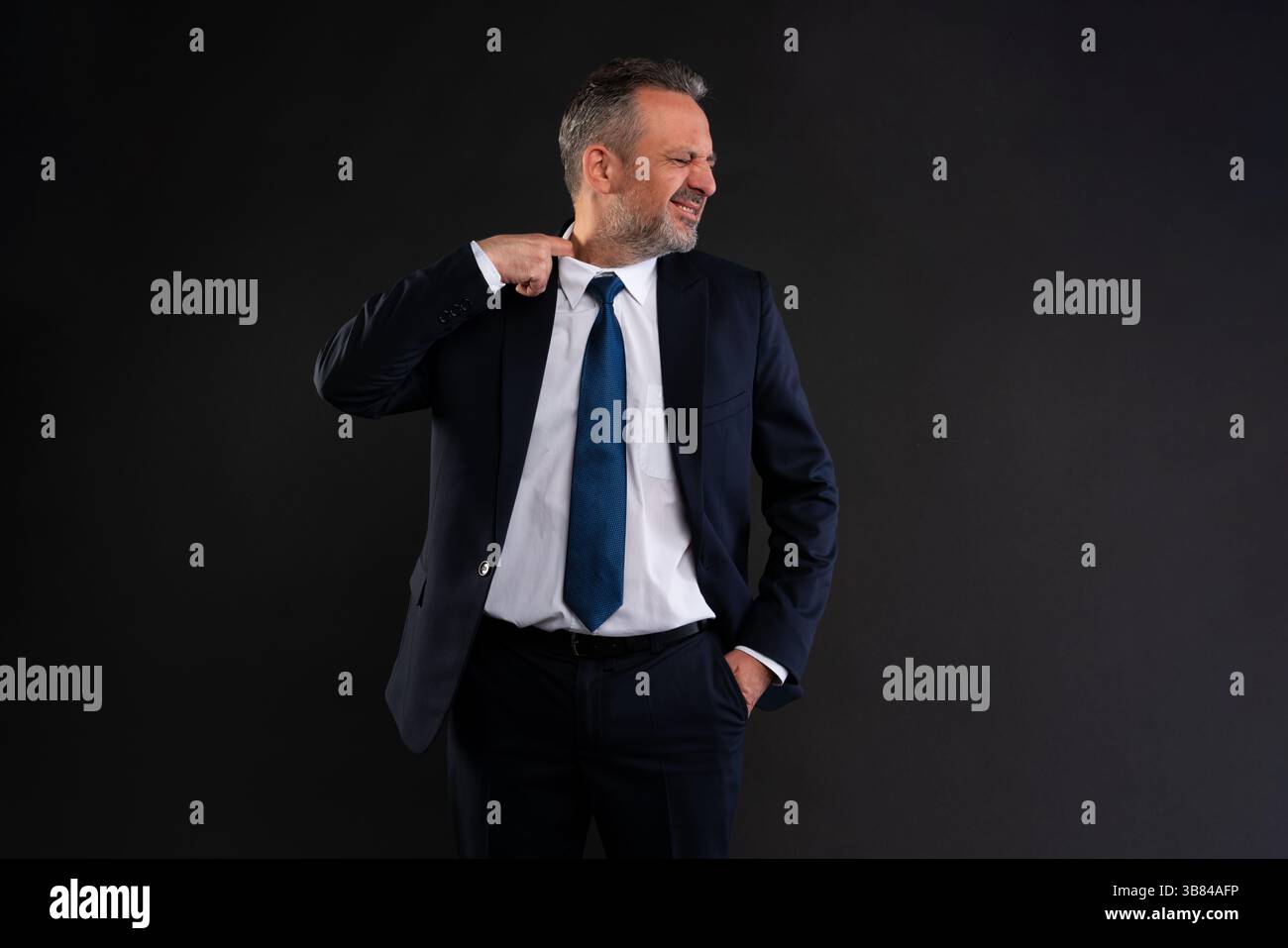 Businessman in suit pulling on his shirt collar, looking uncomfortable ...