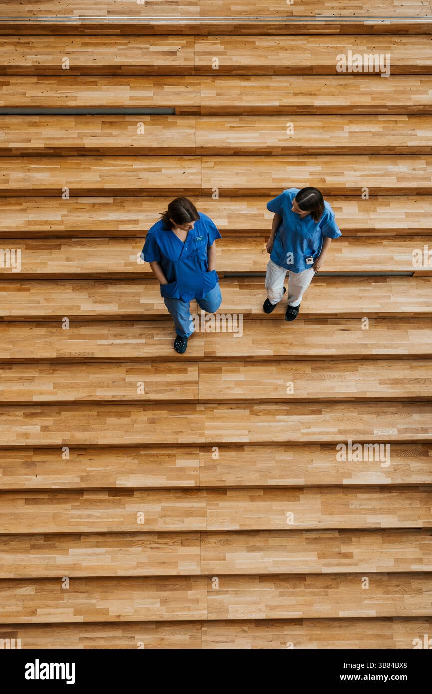 Directly above shot of female doctors talking with each other while moving down steps Stock ...