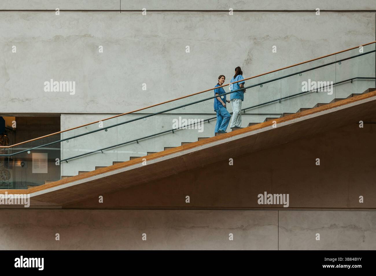 Full length of multiracial female doctors moving up stairs while ...
