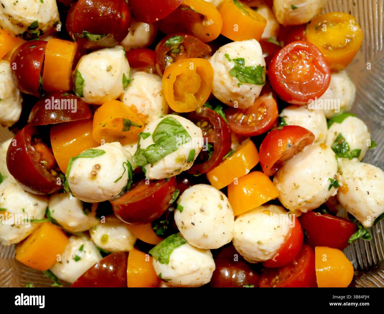 Tomato salad with mozzarella balls, yellow and red cocktail tomatoes ...
