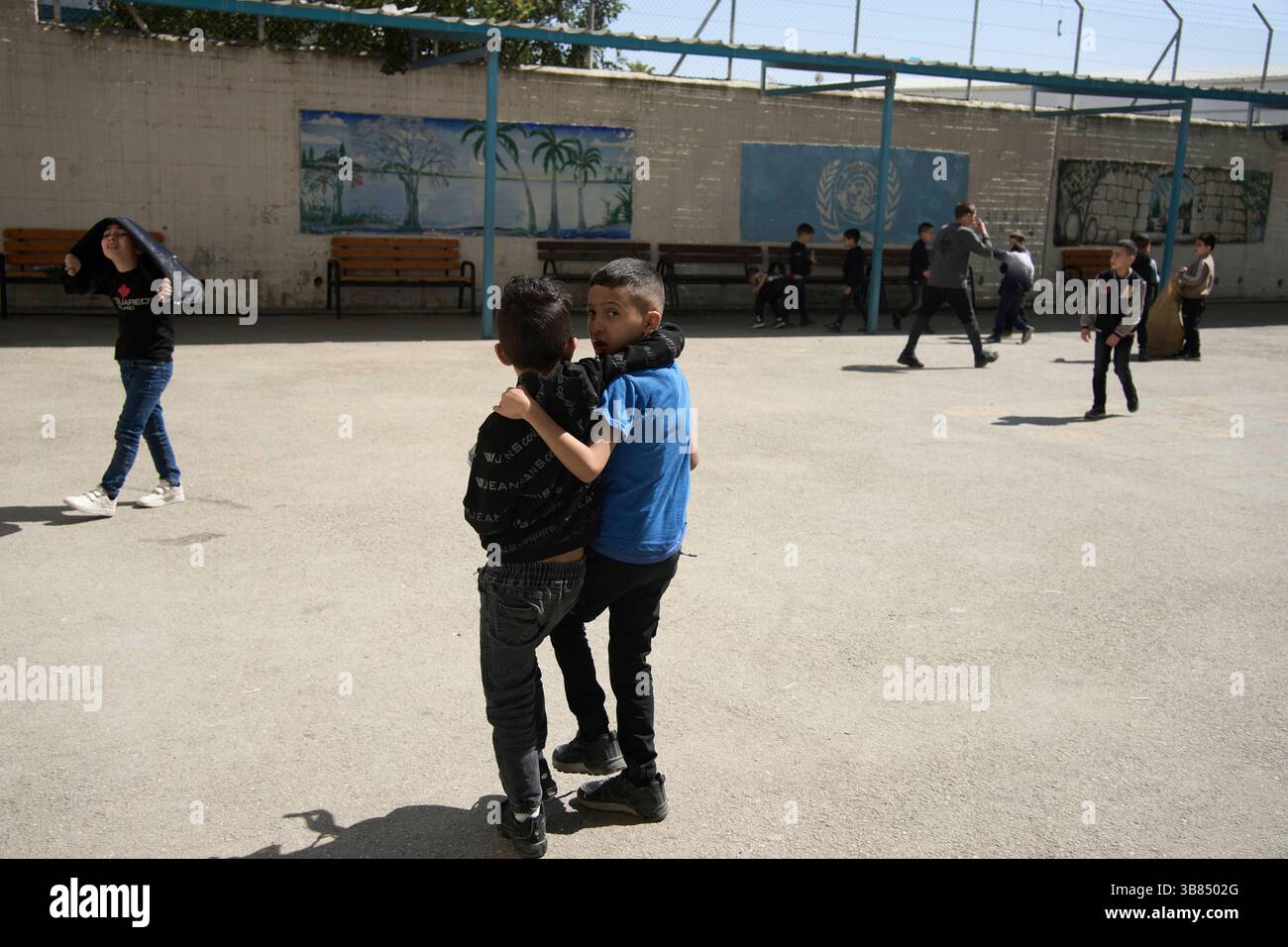 Students play outside during recess at the UNRWA Boys' School run by ...