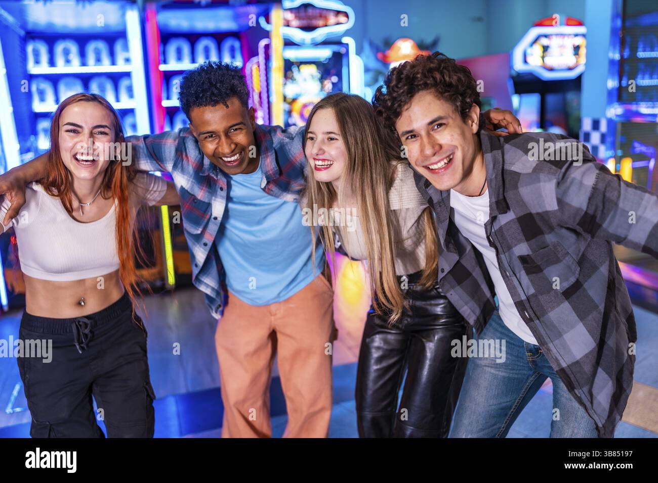 Four young cheerful multi ethnic friends are hugging each other ...