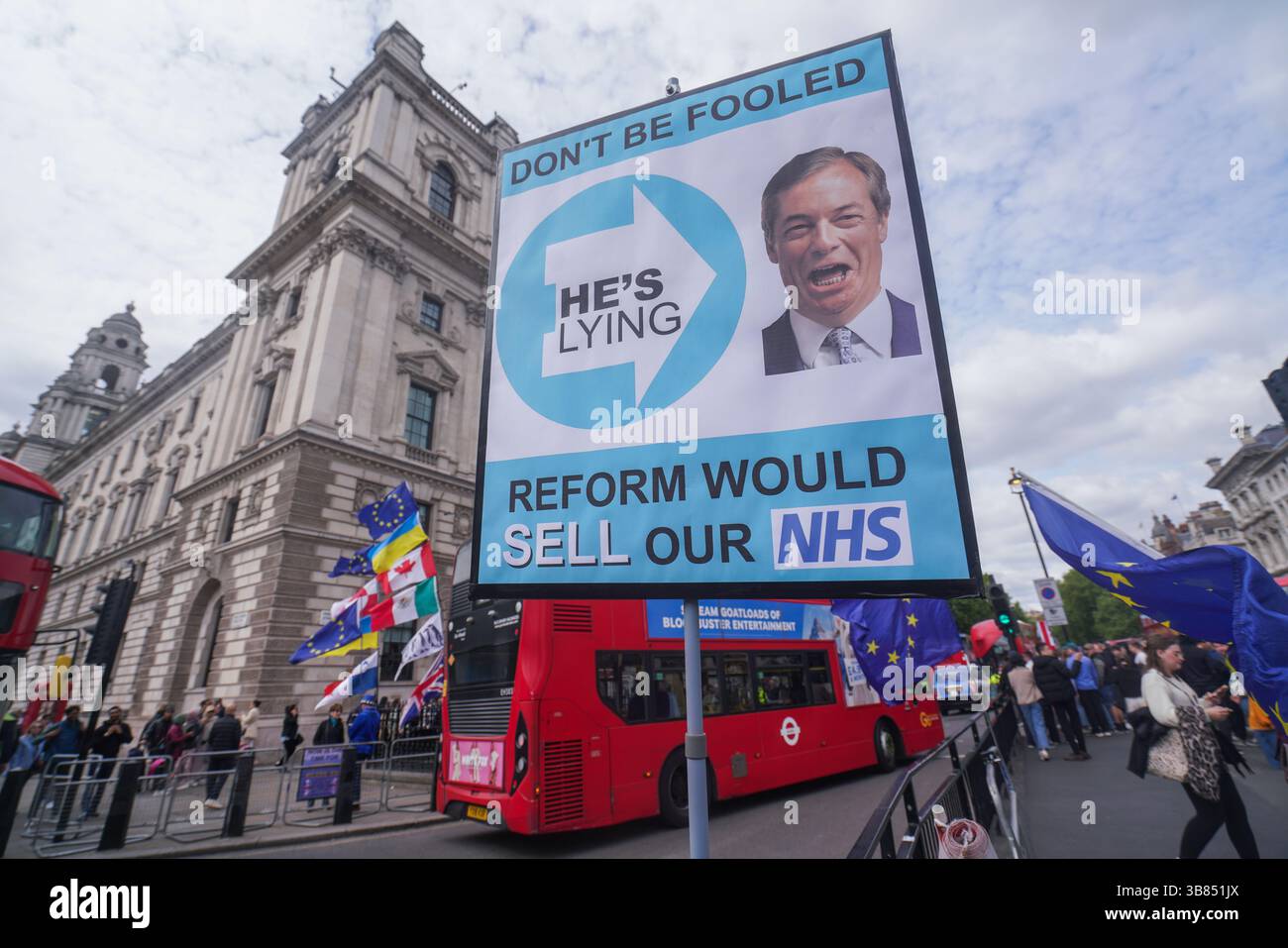 London UK 7 May 2025. A policeman stands next to a picture of Reform UK leader Nigel Farage by ...