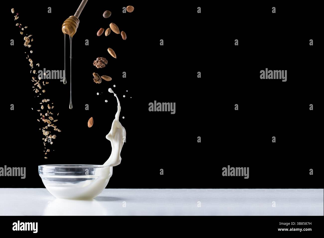 Falling granola with milk splash, falling nuts and honey flows from ...