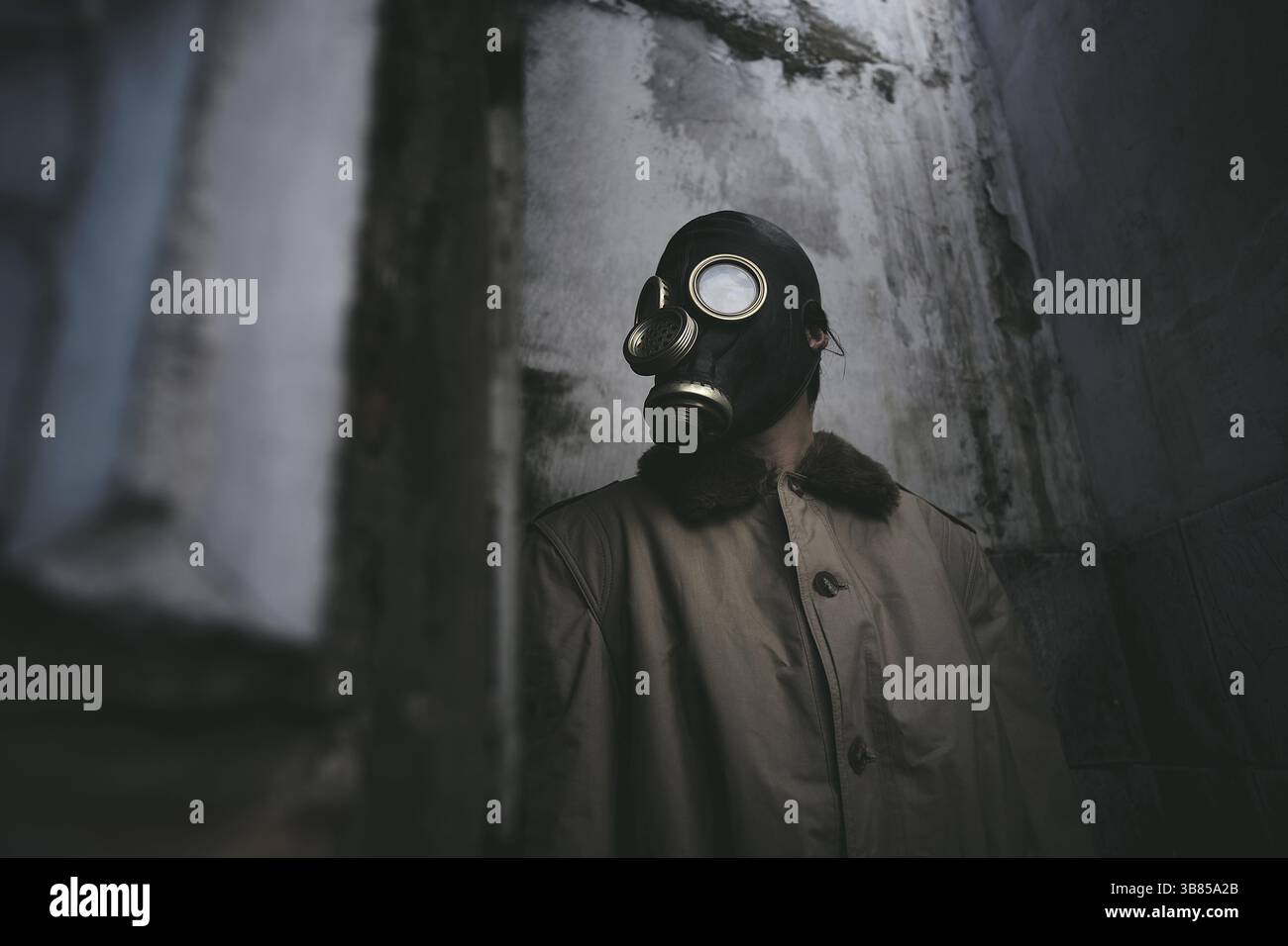 A man in gas mask standing inside an old building, peeking around the corner, good for book ...