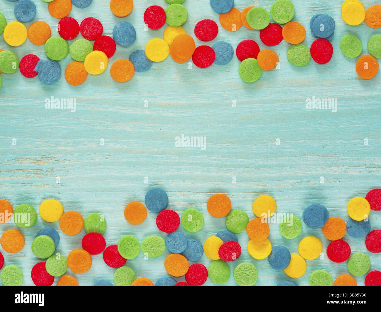 Border frame of colorful sprinkles on blue background with copyspace ...
