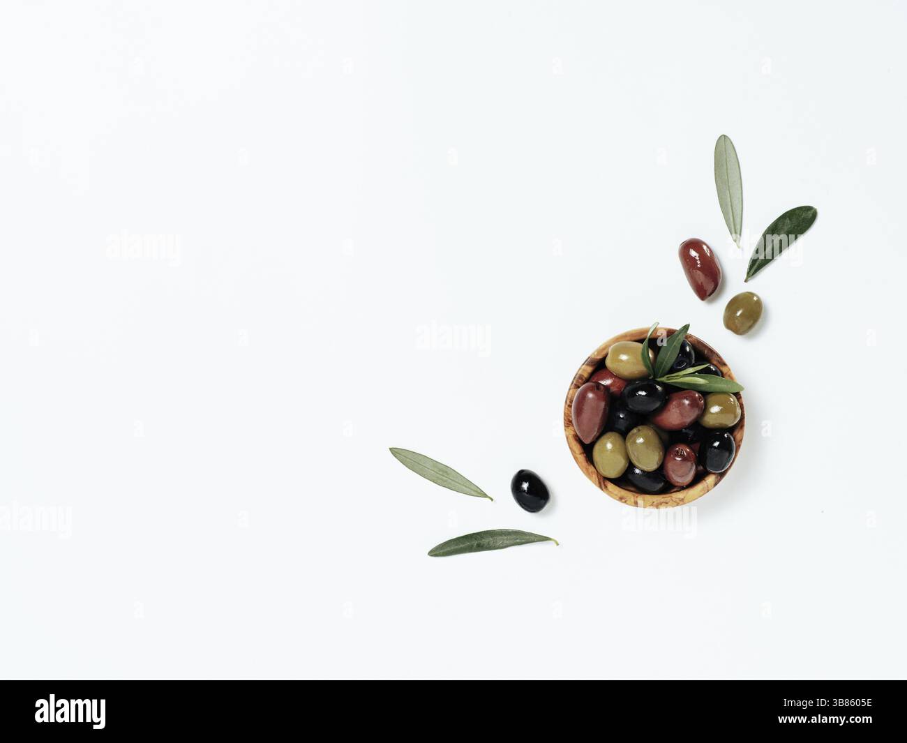 Olives tree leaves and fruits on white background. Small bowl with ...